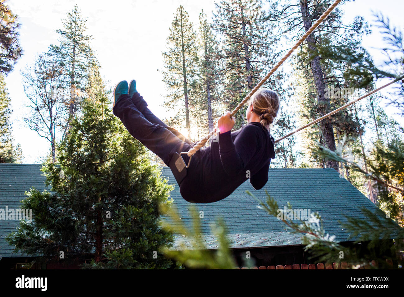 Caucasian woman playing on swing Stock Photo - Alamy
