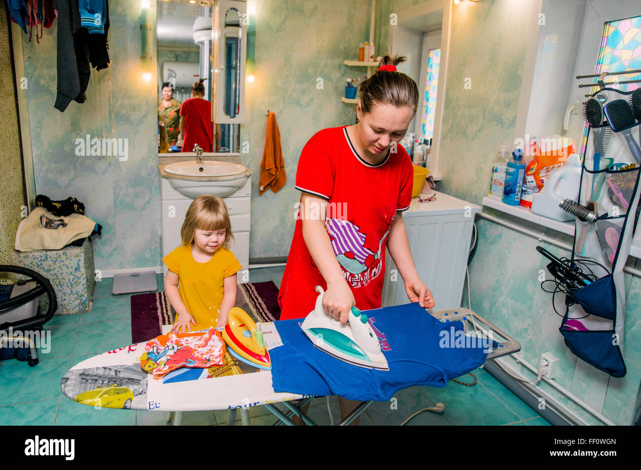 Caucasian mother and daughter ironing laundry Stock Photo - Alamy