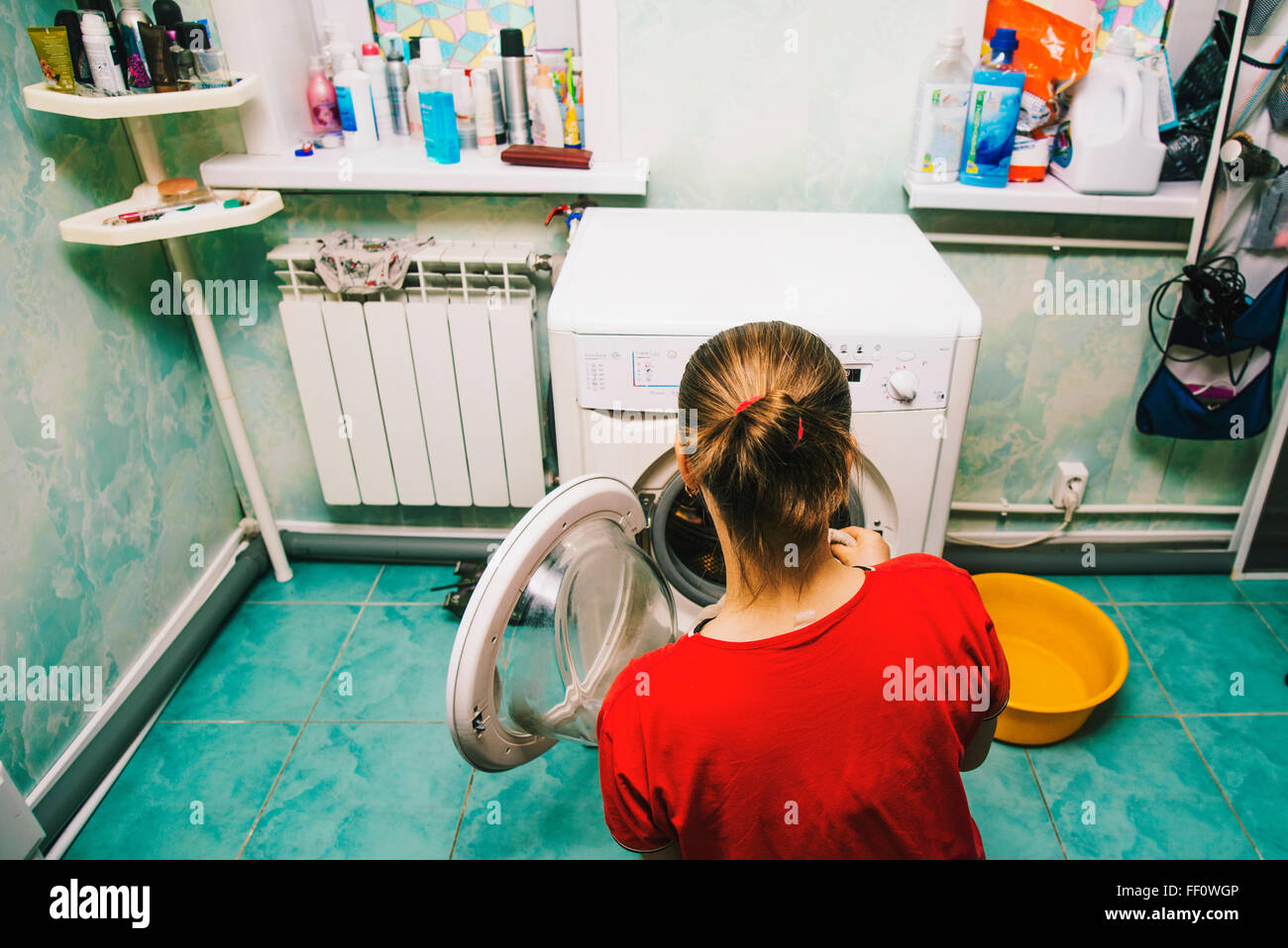 Caucasian woman loading laundry in dryer Stock Photo - Alamy