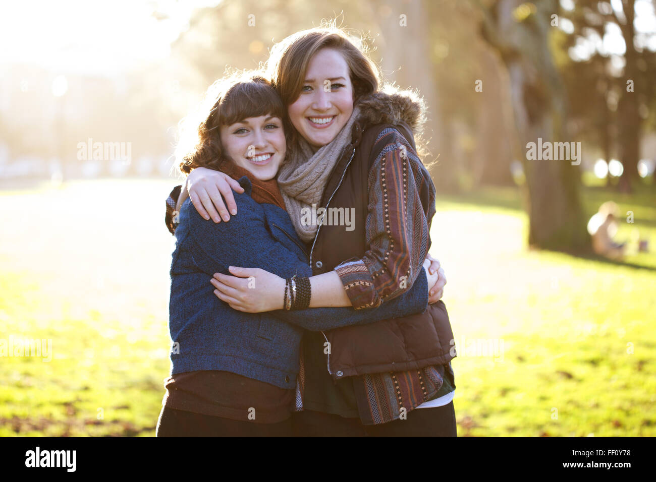 Two young lady friends hugging, smiling and looking at the camera Stock ...
