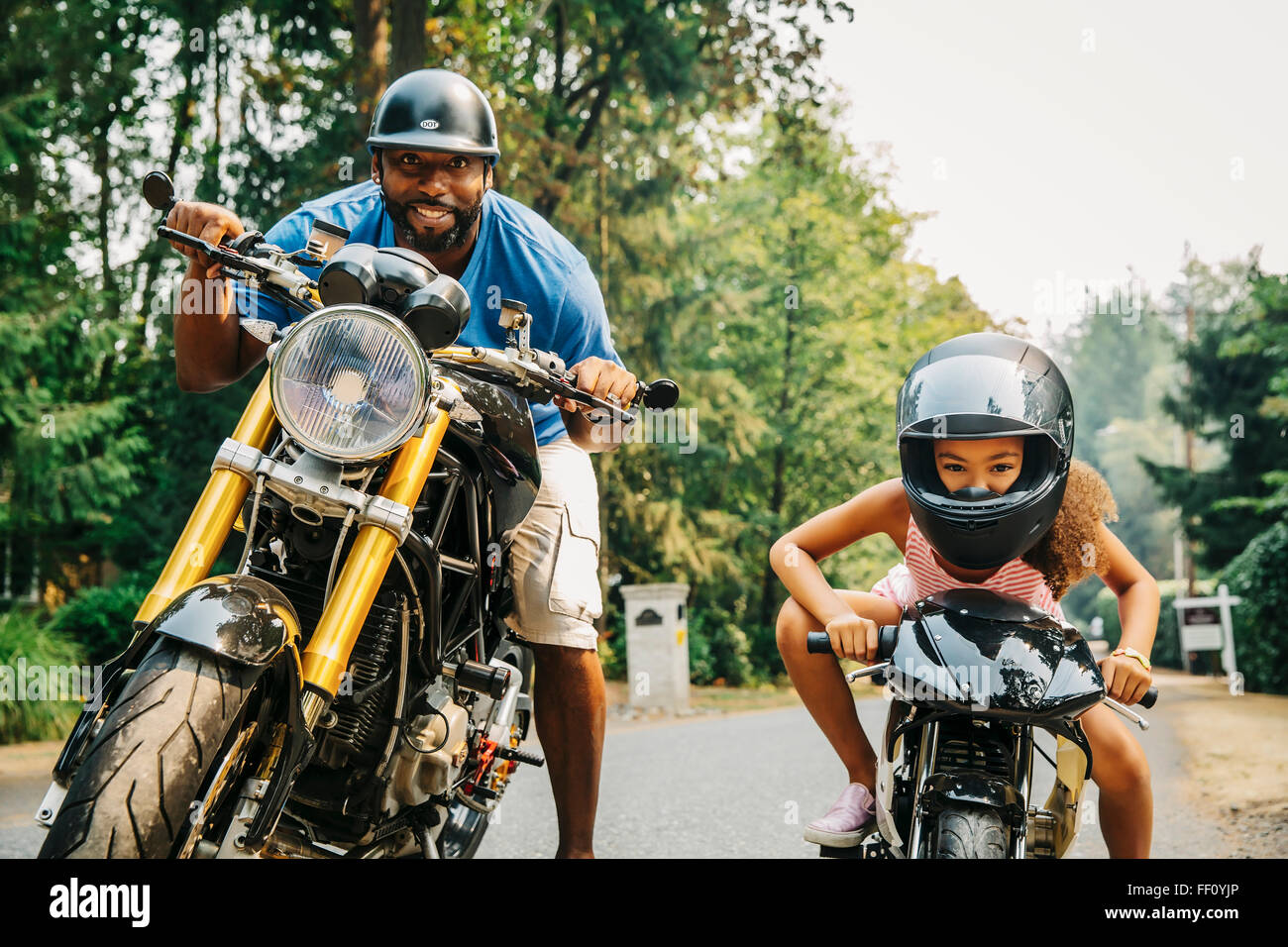 Father and daughter sitting on motorcycles Stock Photo - Alamy