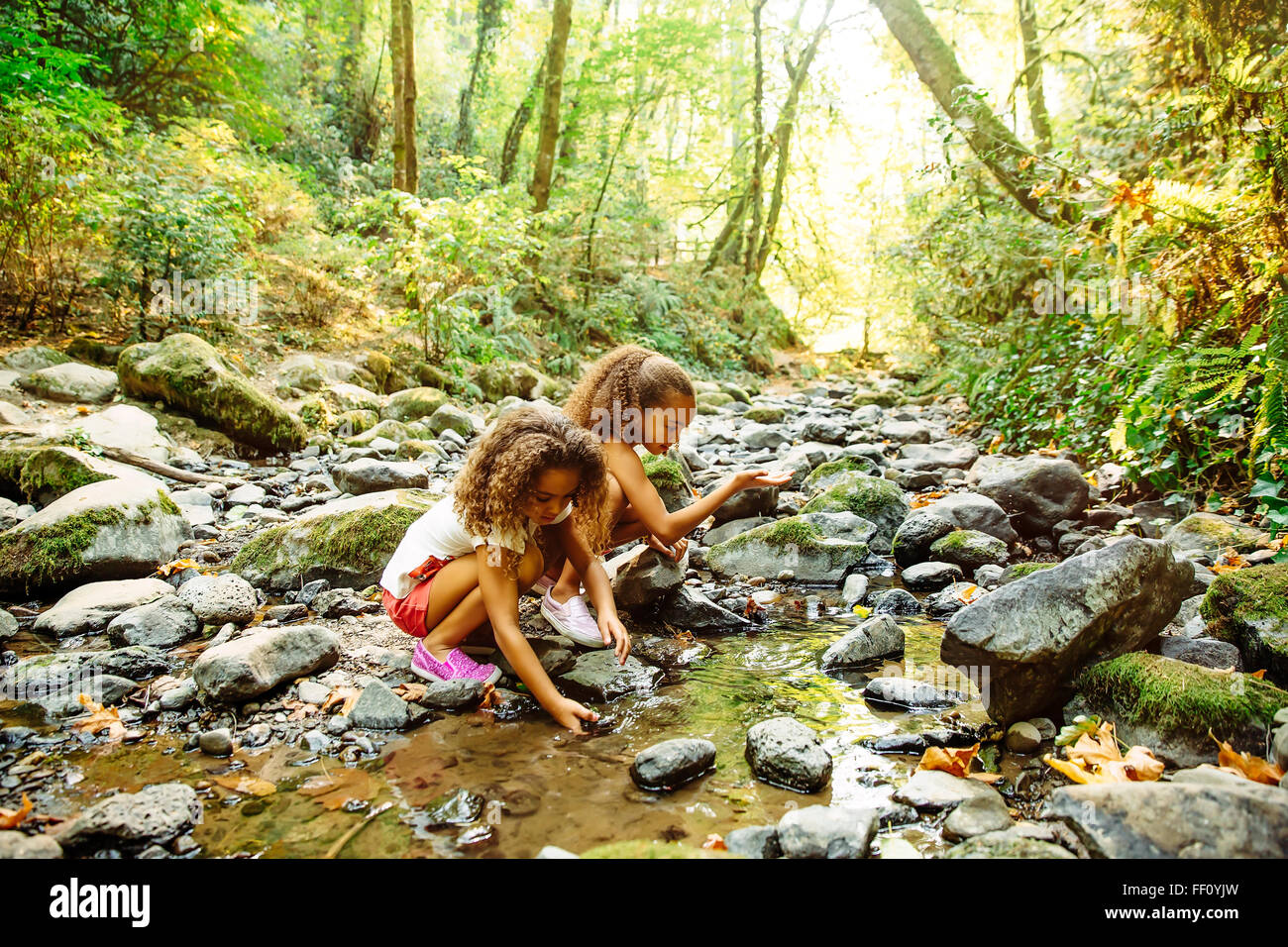 Mixed Race Sisters Exploring Stream Stock Photo Alamy