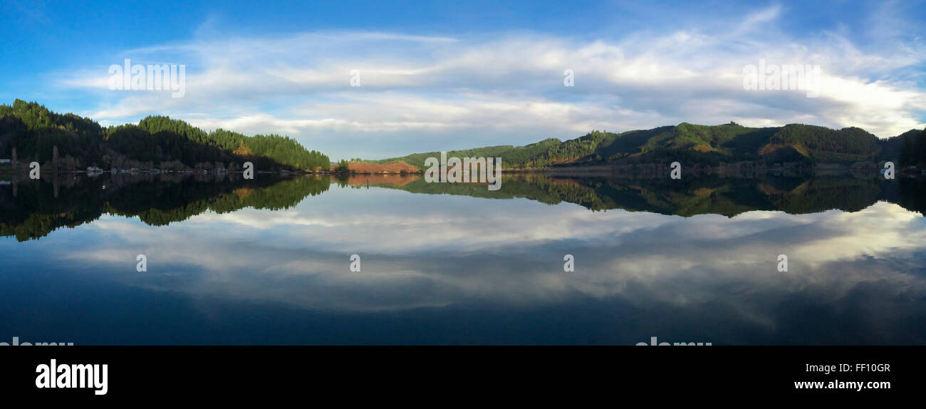 Mirror-like panorama of Triangle Lake, Oregon, USA with green hills ...