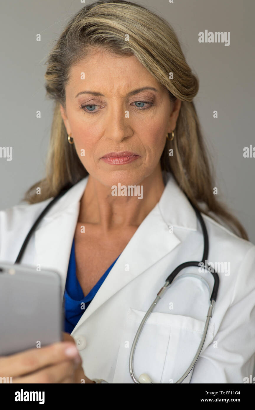 Caucasian doctor using cell phone Stock Photo - Alamy