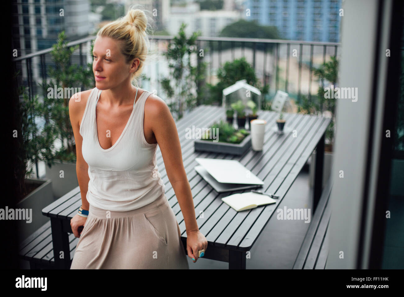 Caucasian woman standing on balcony Stock Photo - Alamy