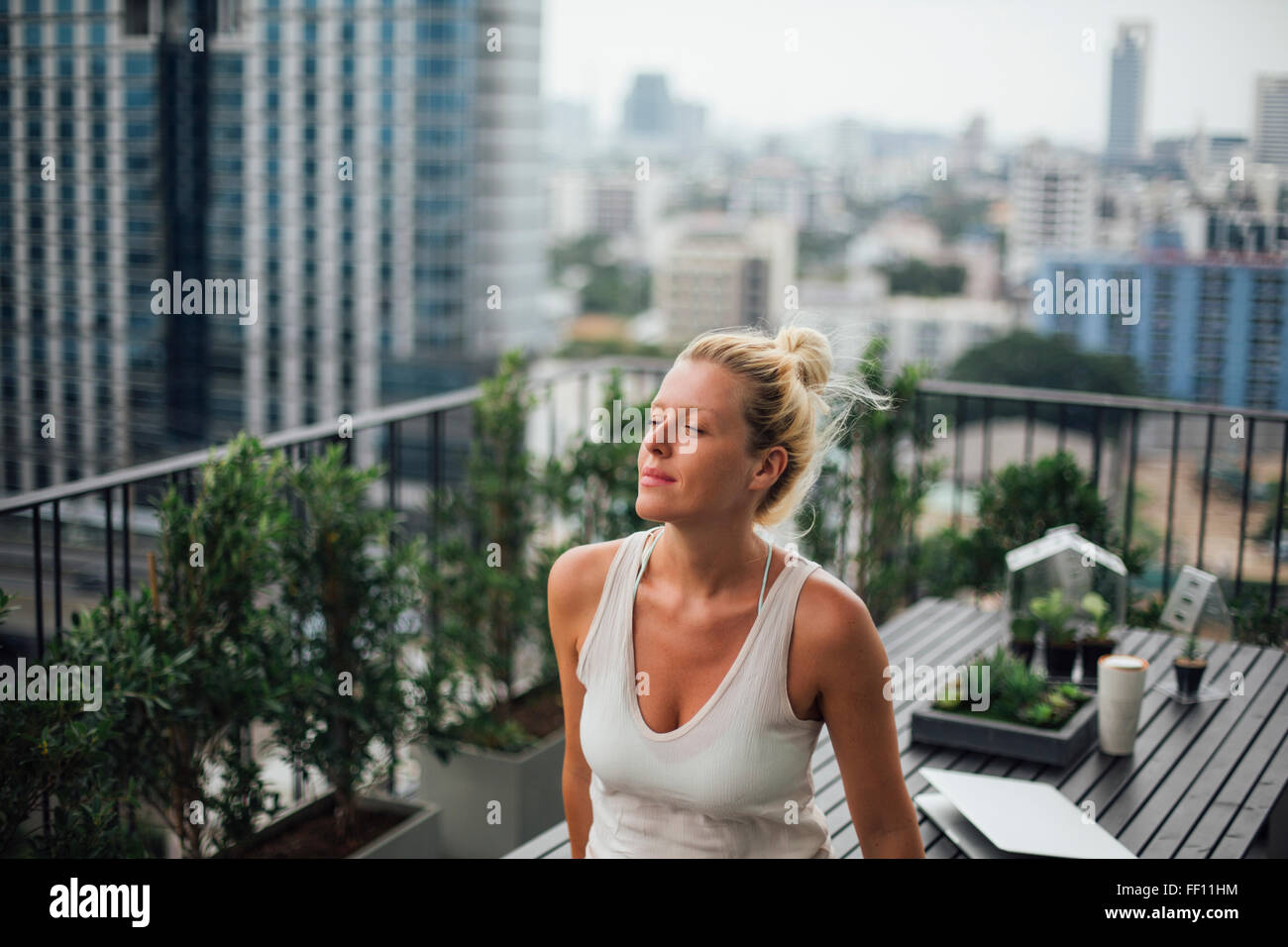 Blond woman sitting balcony hi-res stock photography and images - Alamy