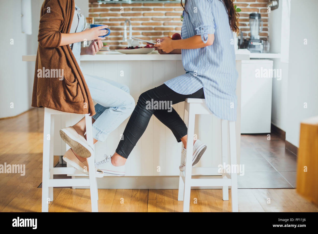 Caucasian women sitting at counter Stock Photo - Alamy
