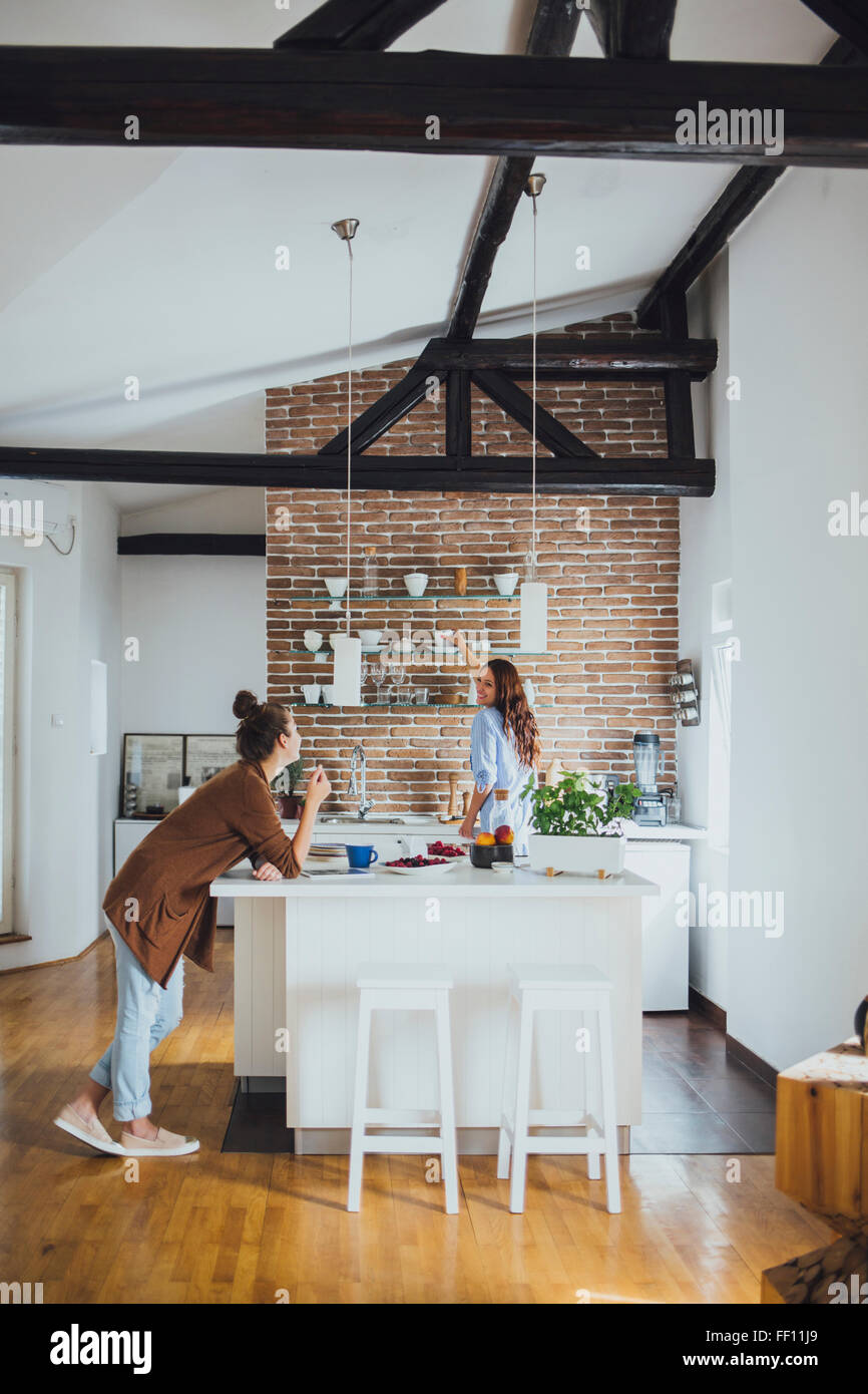 Caucasian women talking in kitchen Stock Photo - Alamy