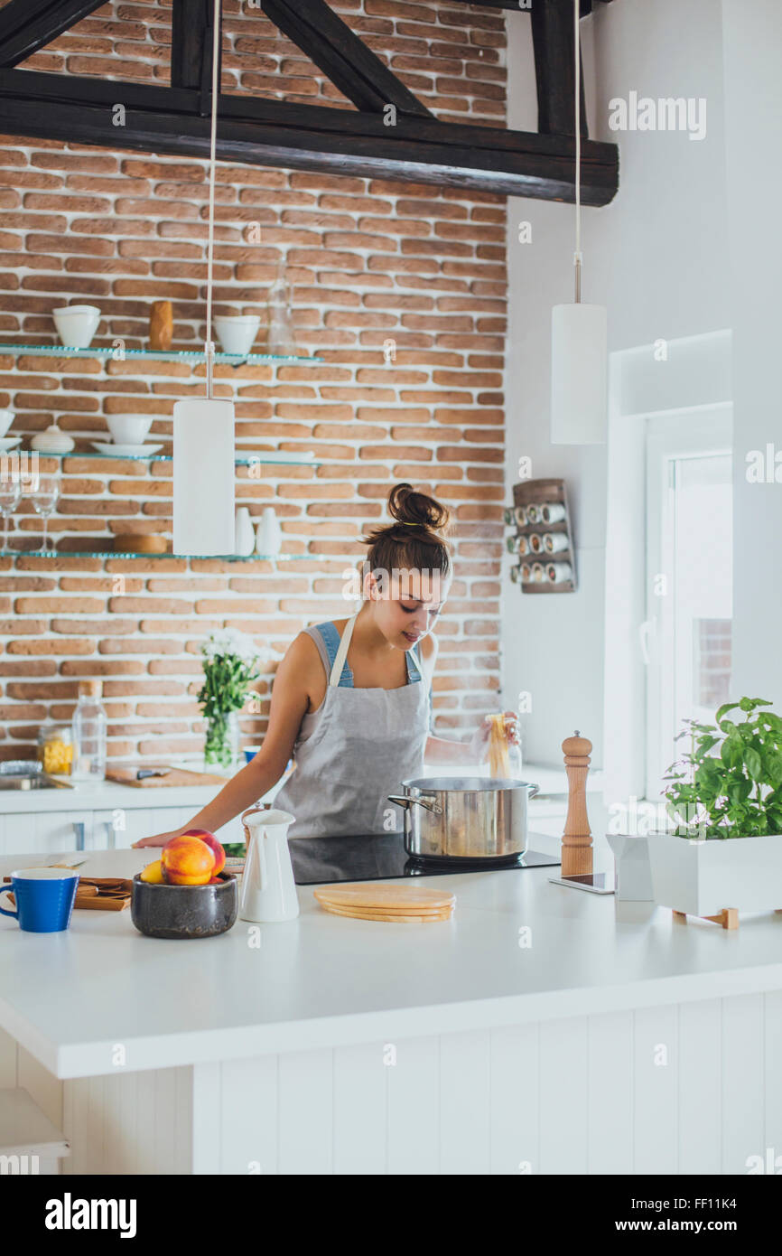 Young woman while cooking hi-res stock photography and images - Alamy