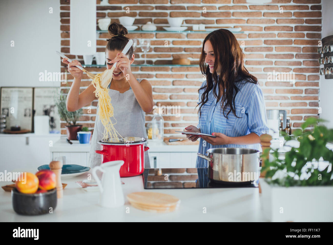 Caucasian women cooking pasta in kitchen Stock Photo - Alamy