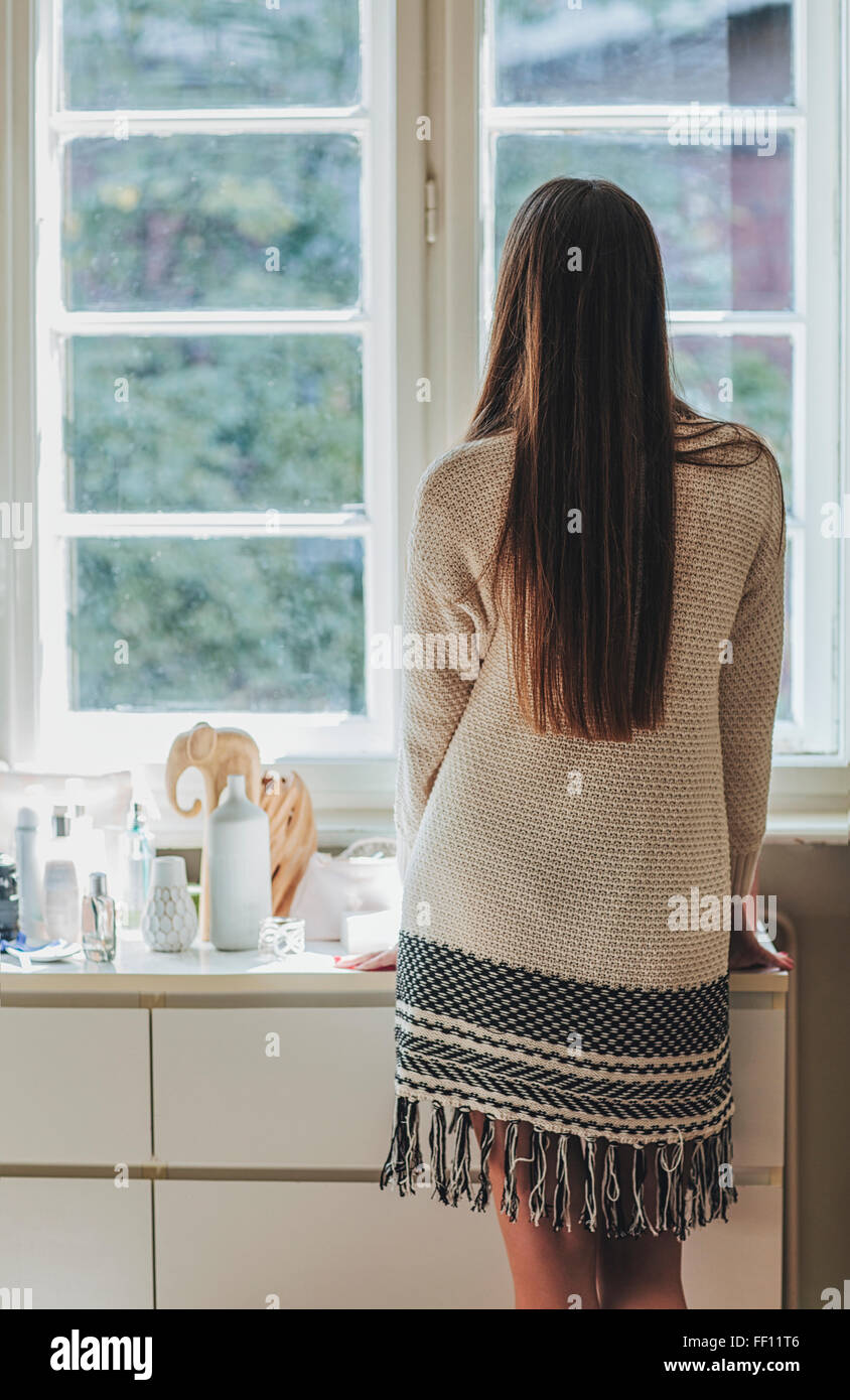 Caucasian woman looking out window Stock Photo - Alamy