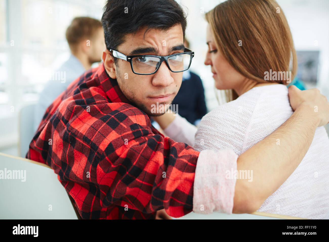 Confused guy looking at camera while reassuring his groupmate at ...