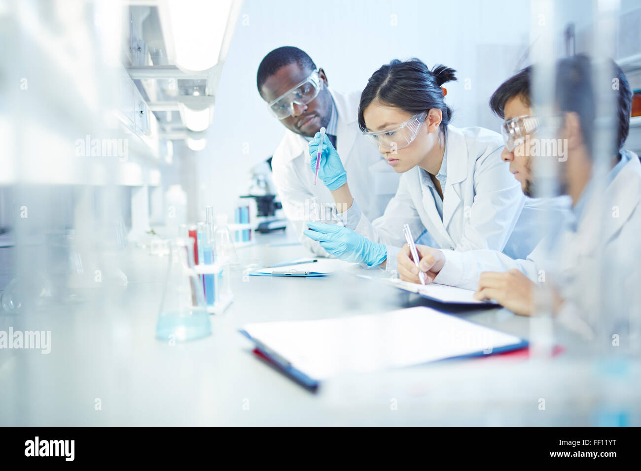 Group of scientists studying new substance in laboratory Stock Photo ...
