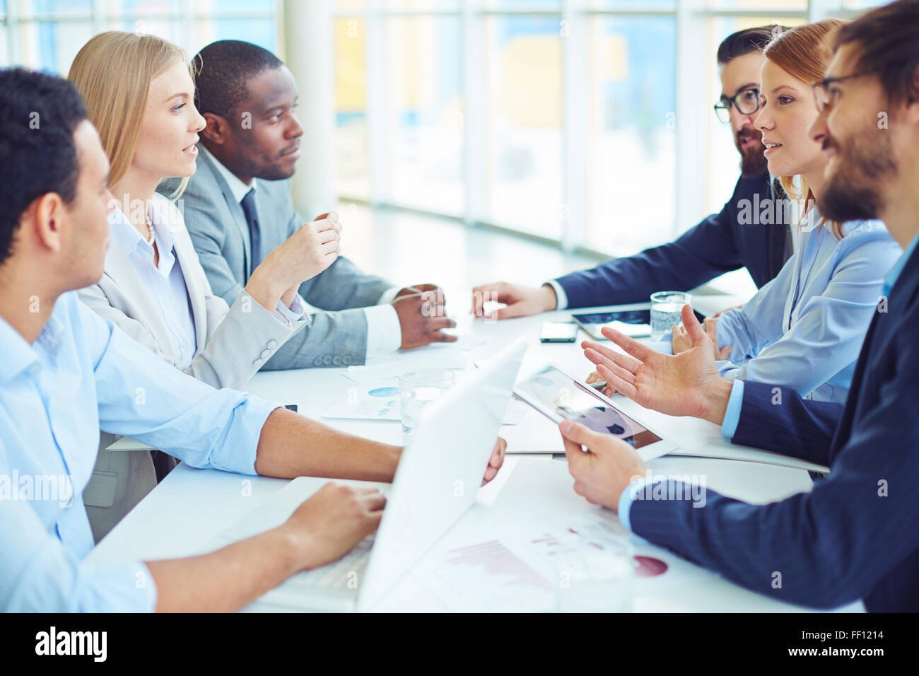 Group of business partners interacting at meeting Stock Photo - Alamy