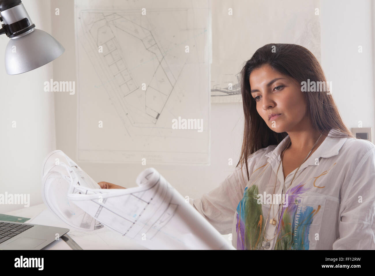 Hispanic architect reading blueprints Stock Photo - Alamy
