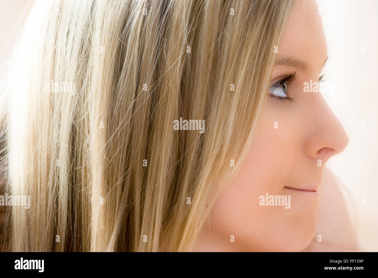 Caucasian blonde blue eyed teenage girl. Side view of face, looking up ...