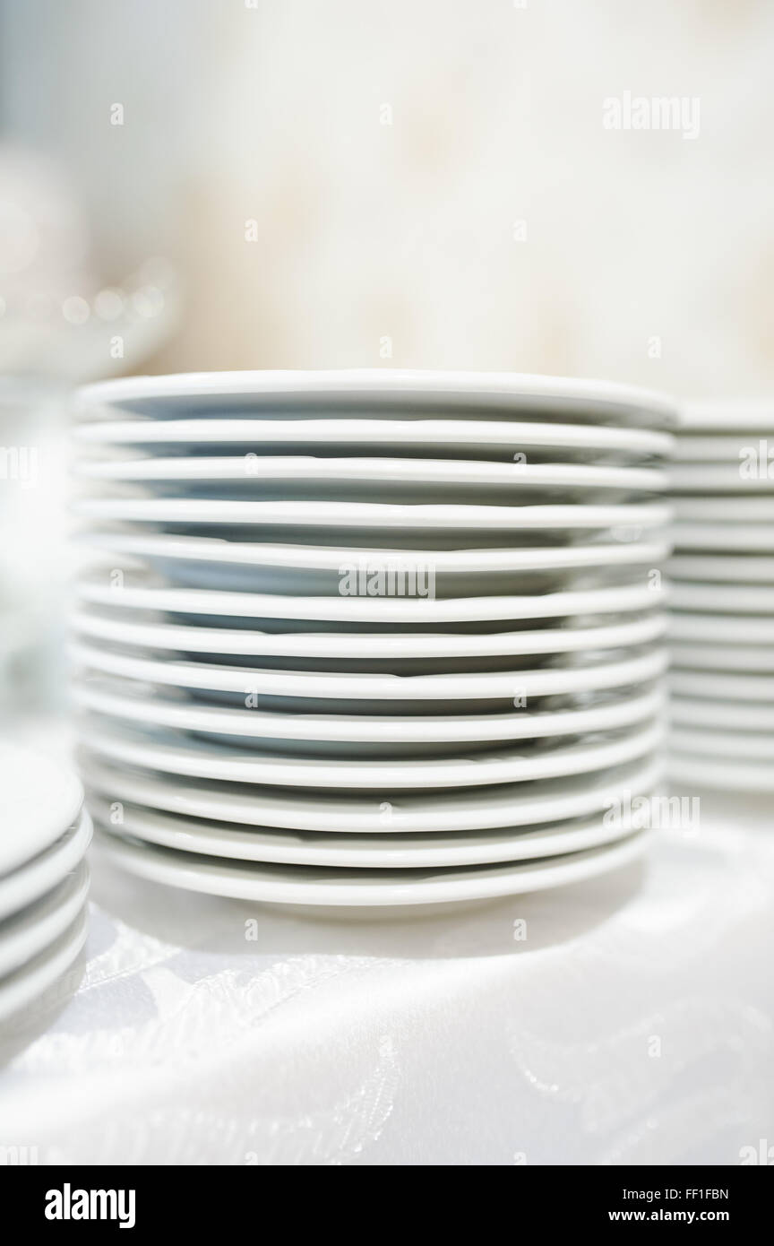 Stack of clean plates ready to be used on dinner Stock Photo - Alamy