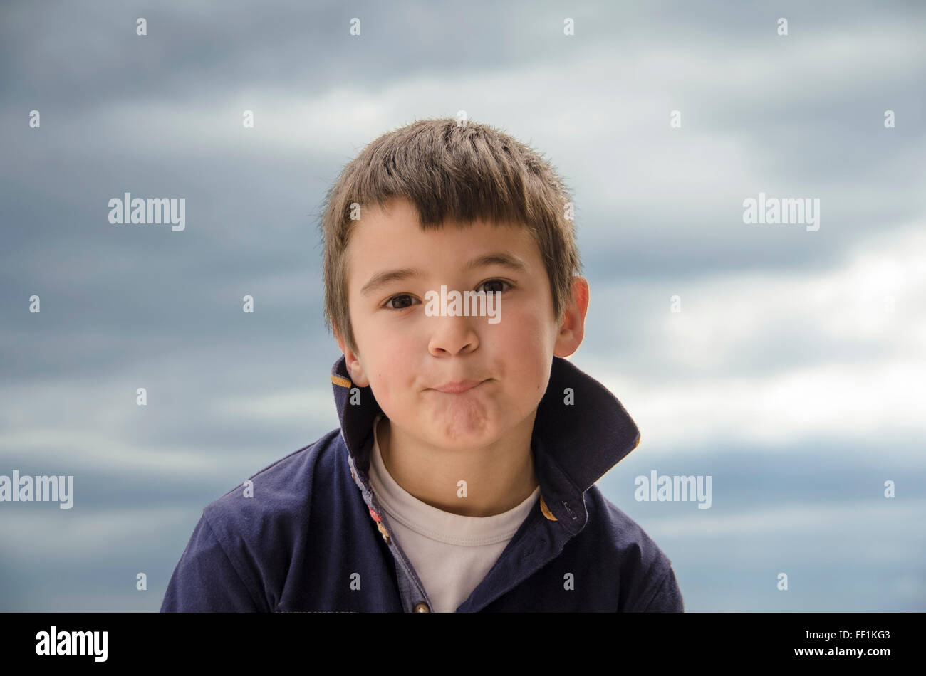 Boy is grimacing on natural background Stock Photo - Alamy