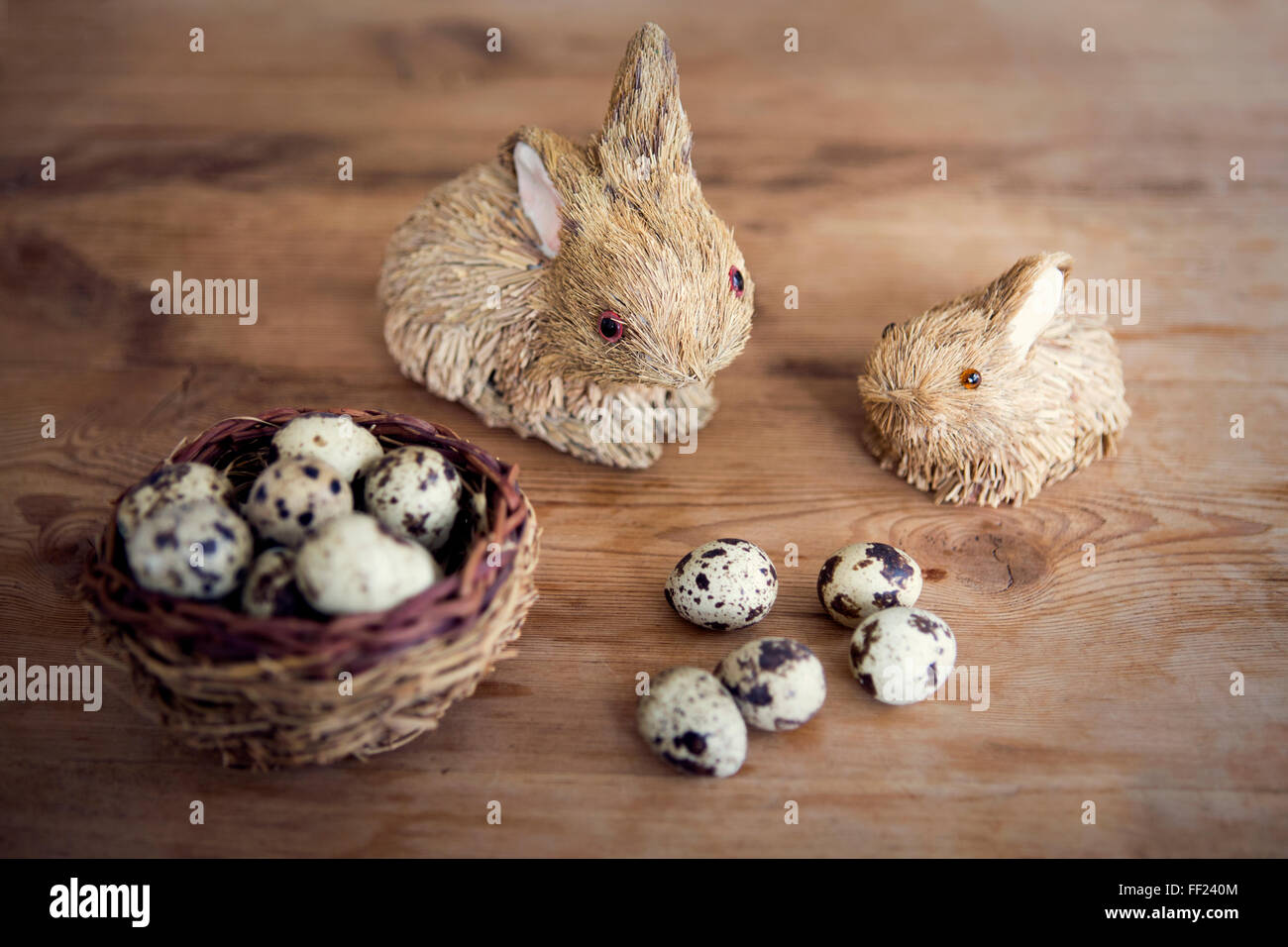 straw easter bunny with basket of quail eggs on wooden table Stock ...