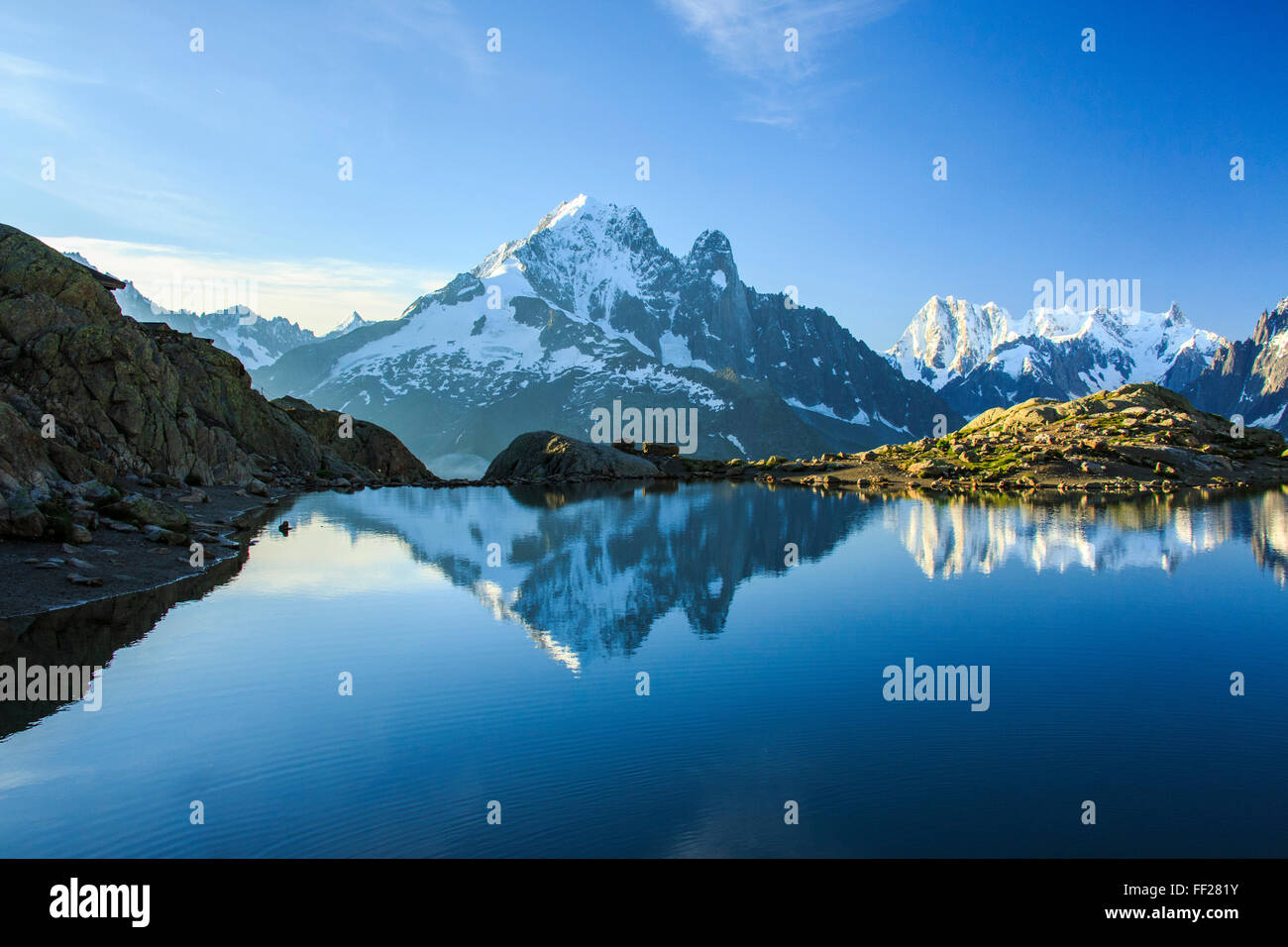 The snowy peaks of Mont Blanc are reflected in the blue water of Lac ...