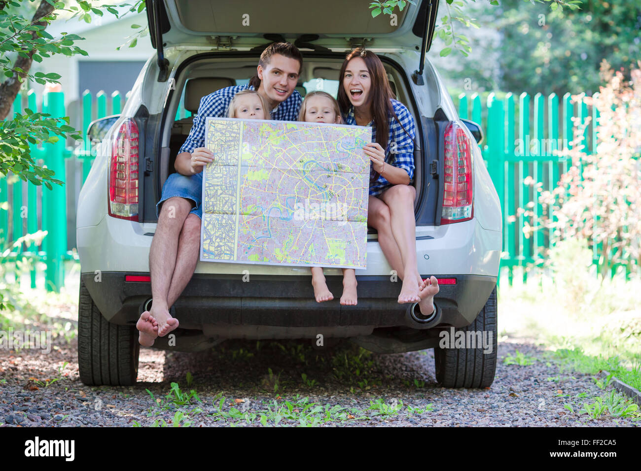 Family with two kids looking at map while traveling by car Stock Photo ...