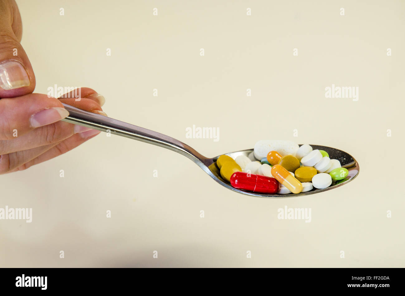 human hand with spoon full of colorful medicals Stock Photo - Alamy
