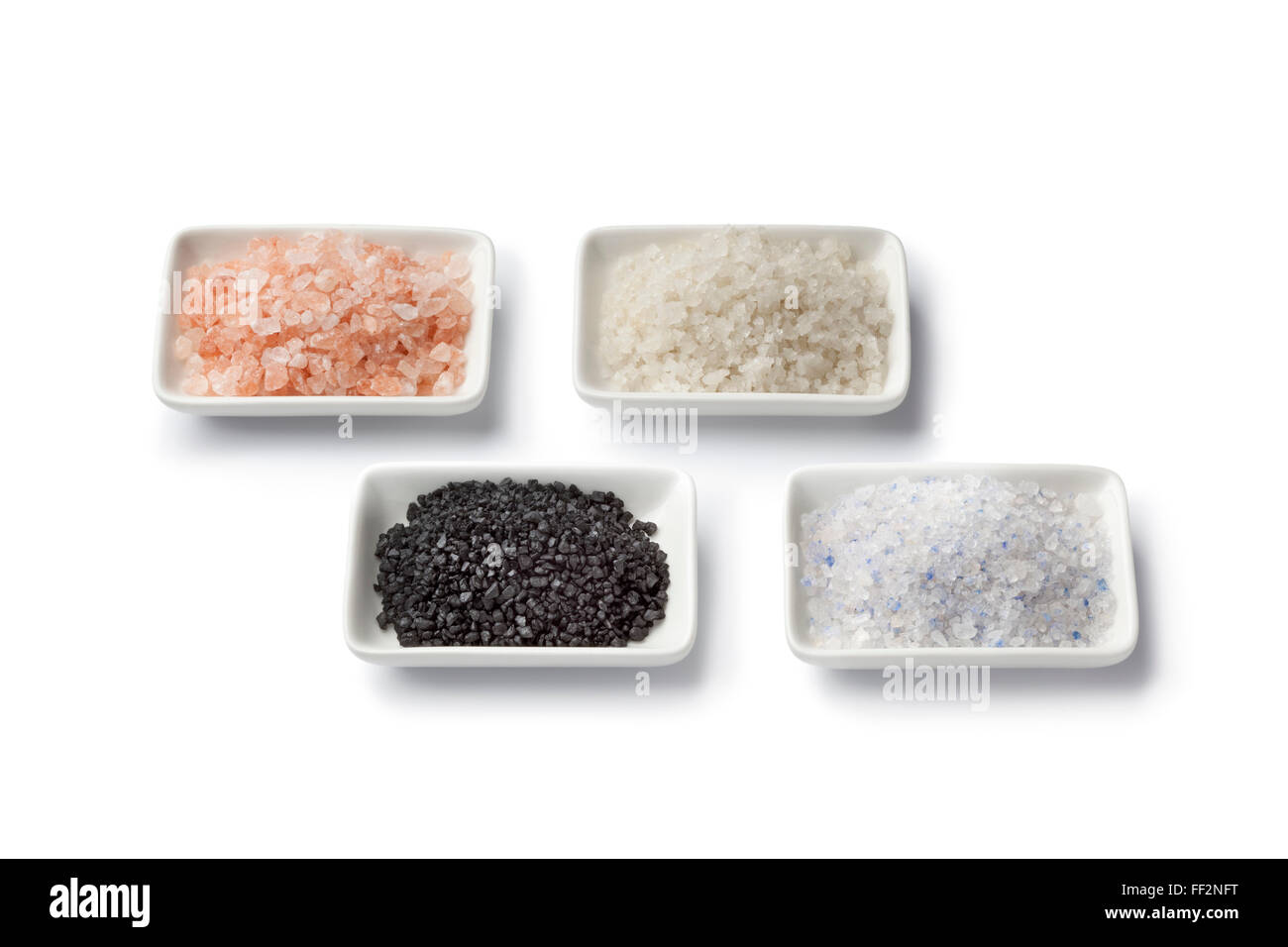 Four various types of salt in white dishes close up Stock Photo - Alamy