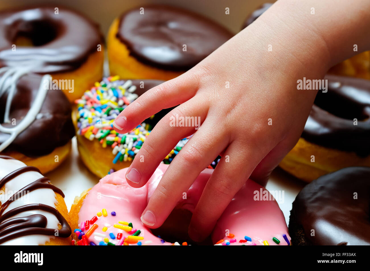 Child grabbing donut hi-res stock photography and images - Alamy