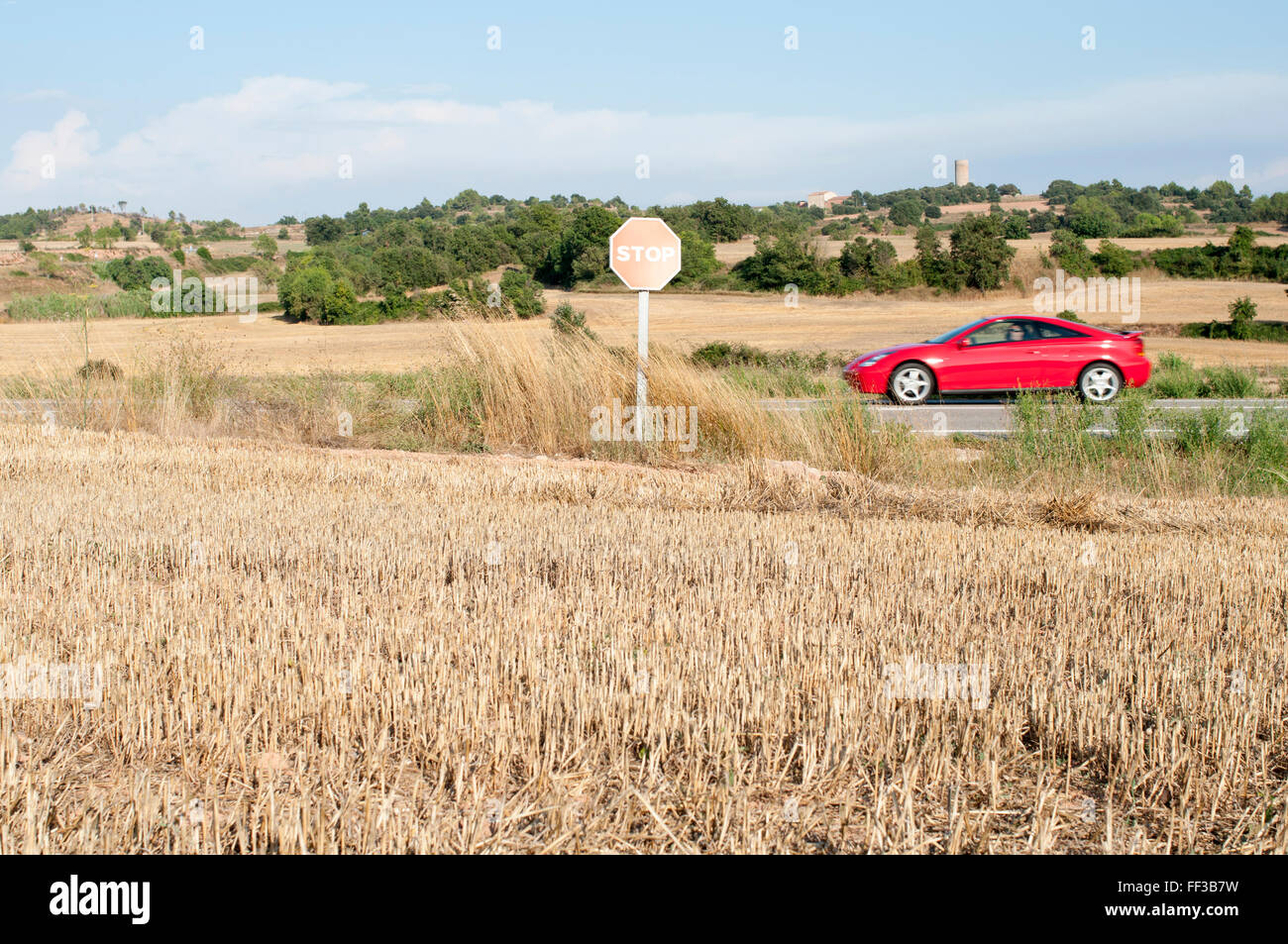 Car passing behind a Stop sign Stock Photo - Alamy