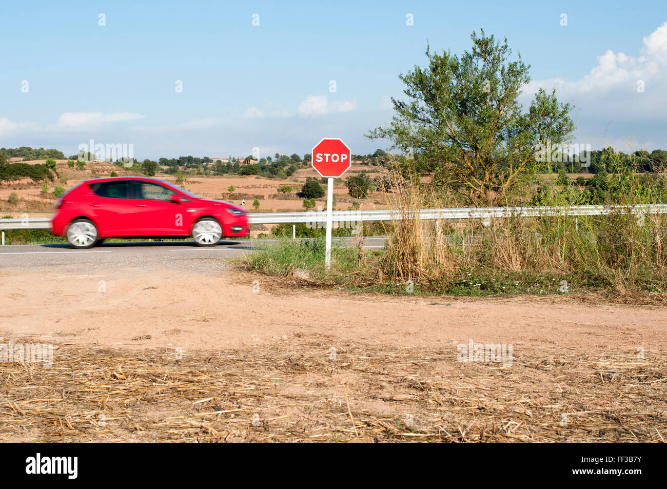 Car passing behind a Stop sign Stock Photo - Alamy