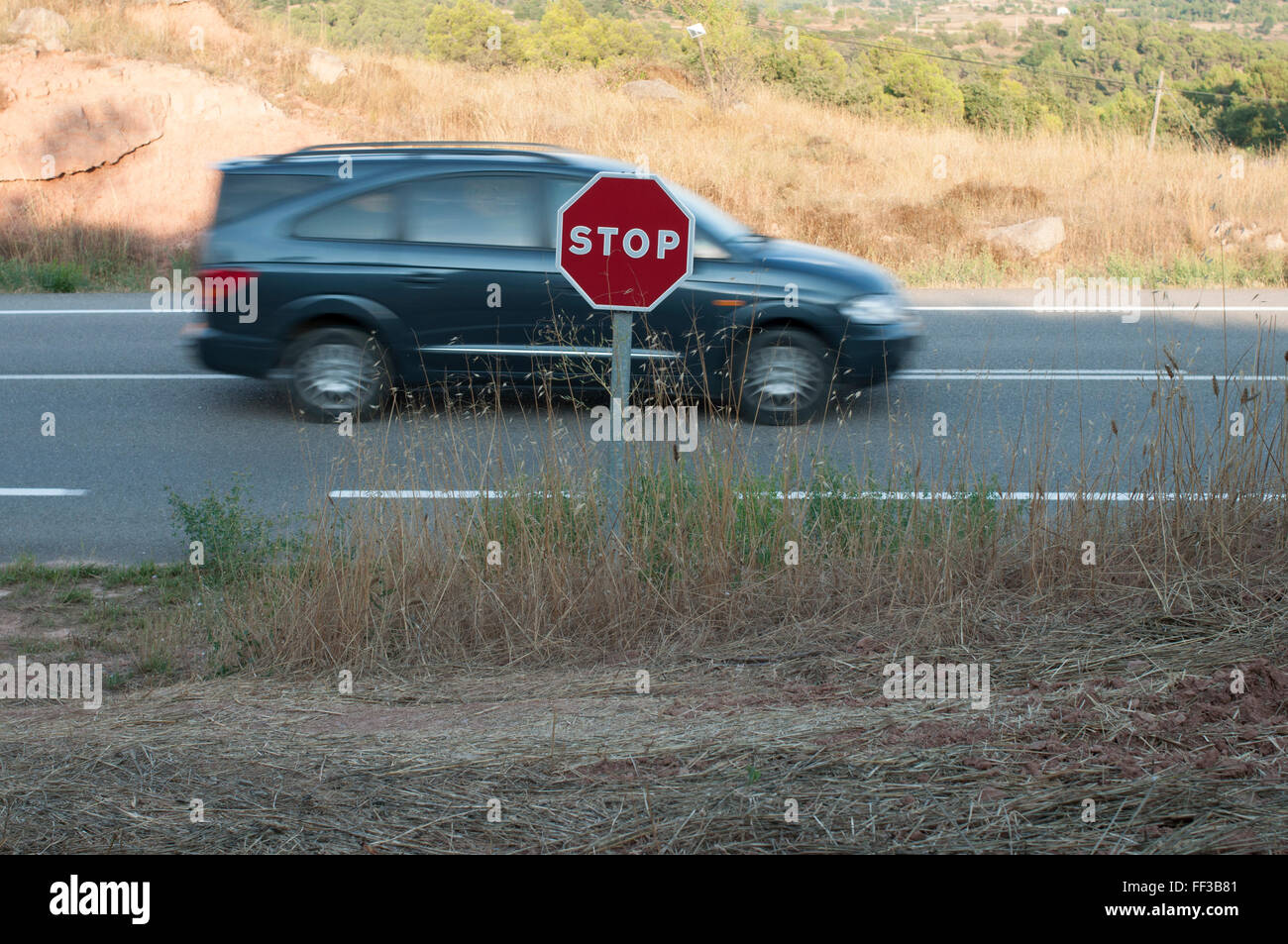 Car passing behind a Stop sign Stock Photo - Alamy