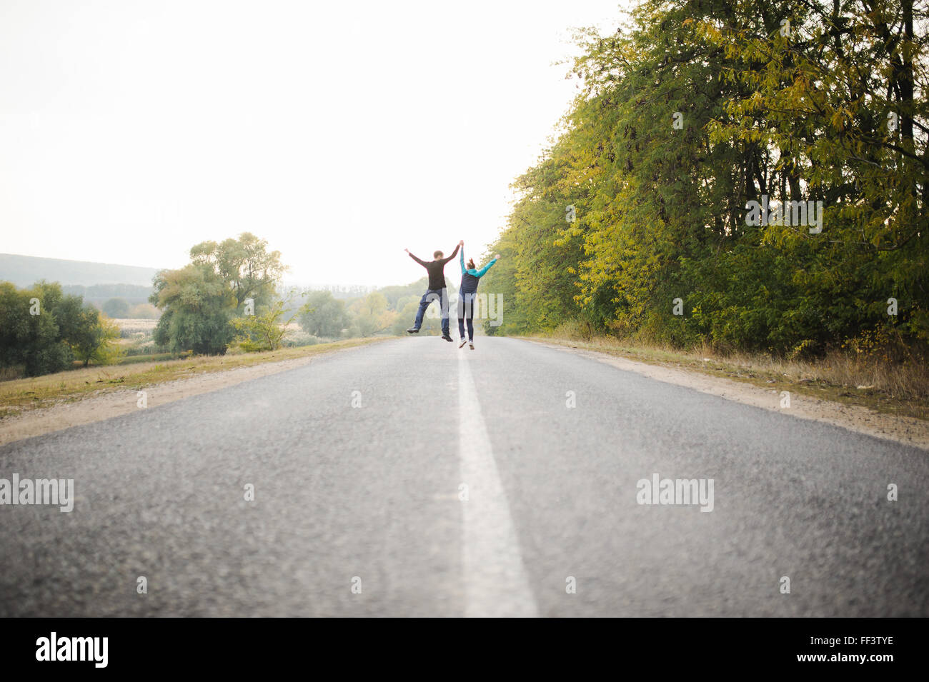 Young couple enjoying a walk on the road, holding hands Stock Photo - Alamy