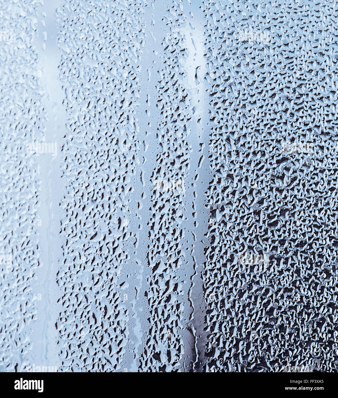 Condensation showing on a glass window with a blue out look from the ...