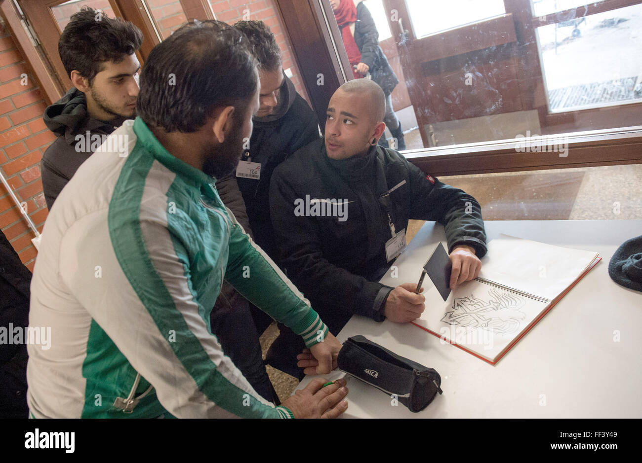 Security guard Orlando List (R) draws a picture depicting the Syrian ...
