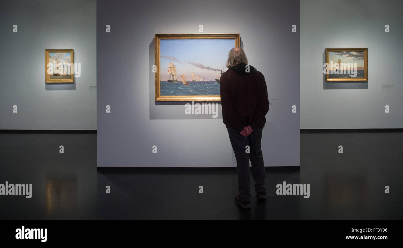 A man looks at paintings by Danish artist Christoffer Wilhelm ...