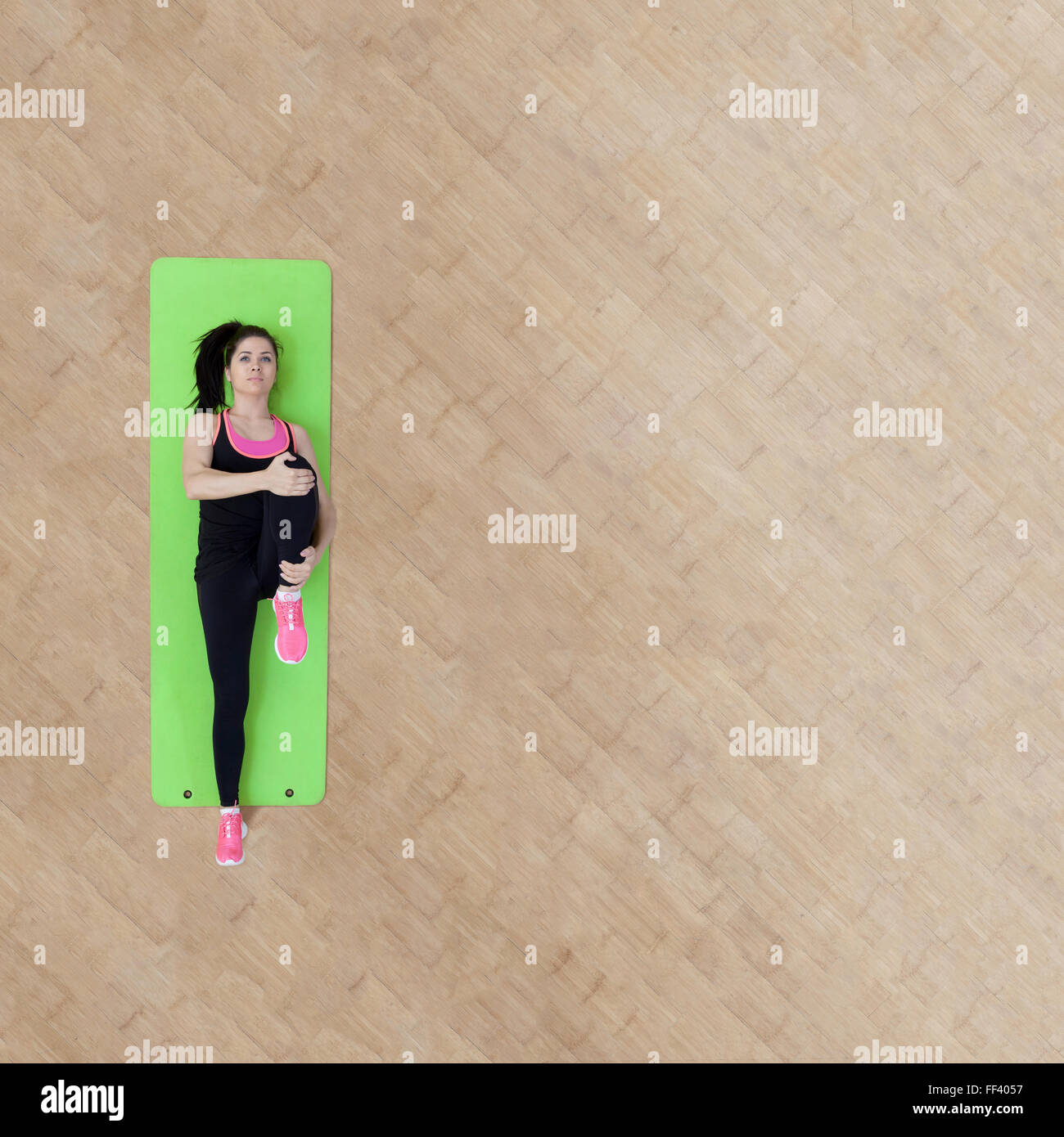 Fitness woman doing stretching exercises on mat. Above image with copy ...