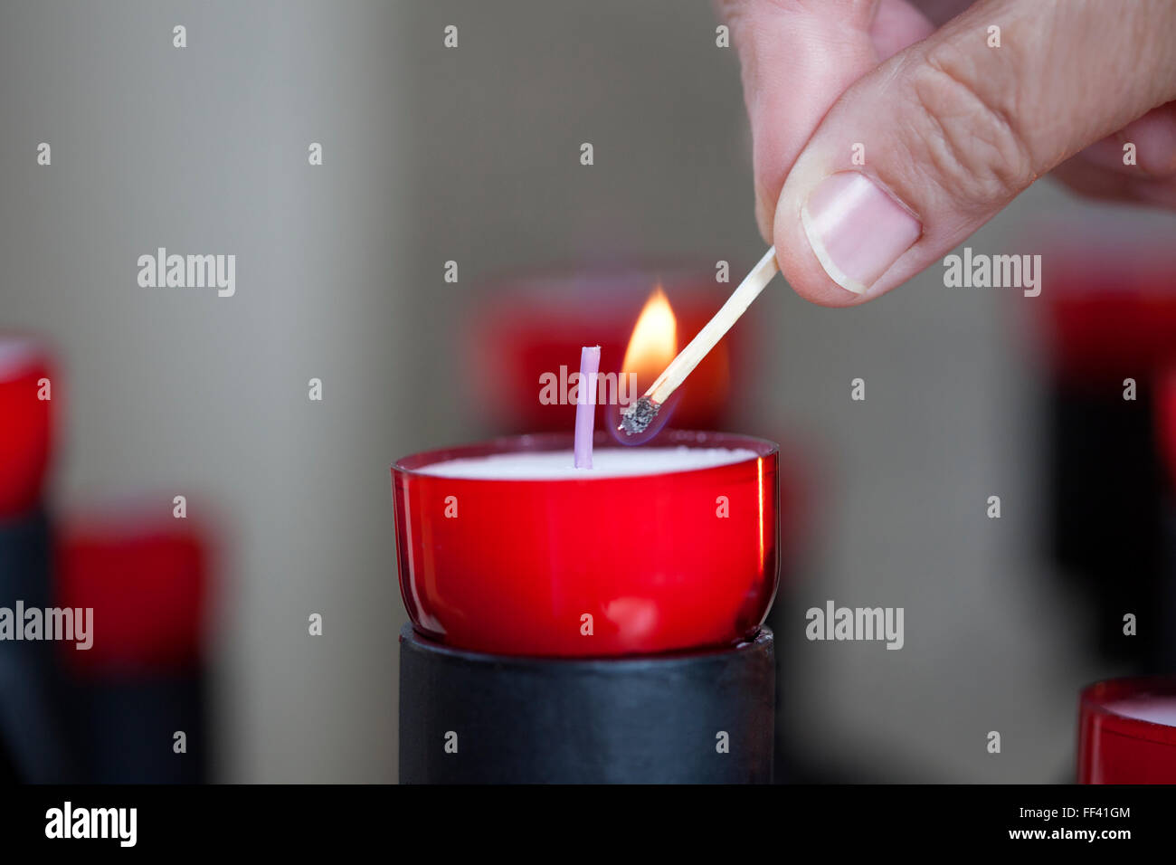 Female mature woman burning a red candle light in church Stock Photo ...
