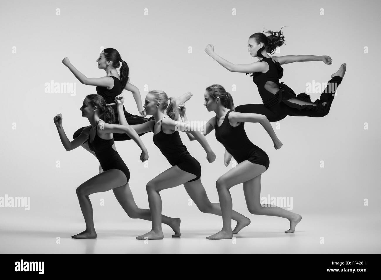 The group of modern ballet dancers dancing on gray background. The ...