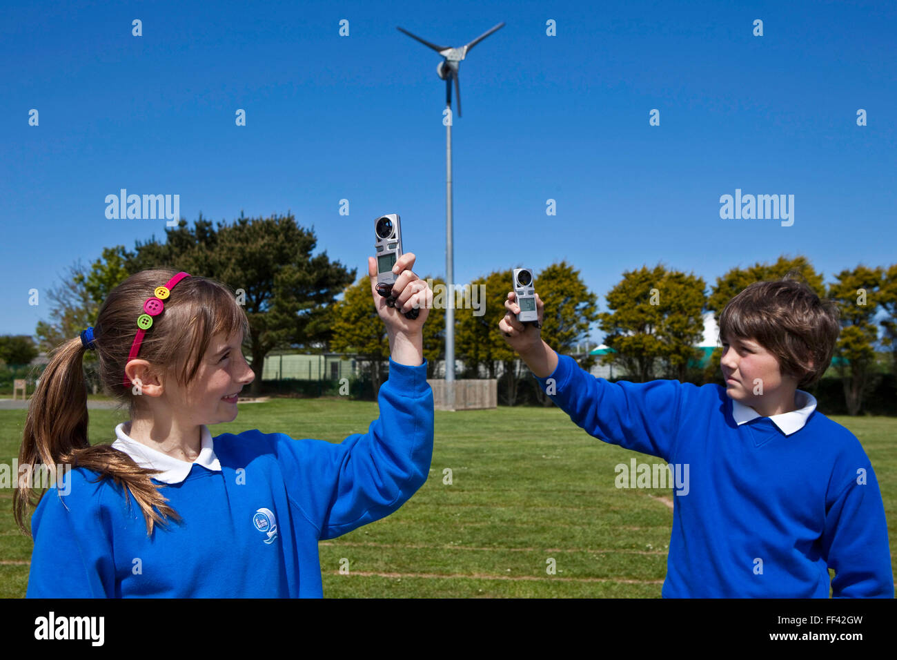 Primary school children measuring wind speeds with anemometers to help ...