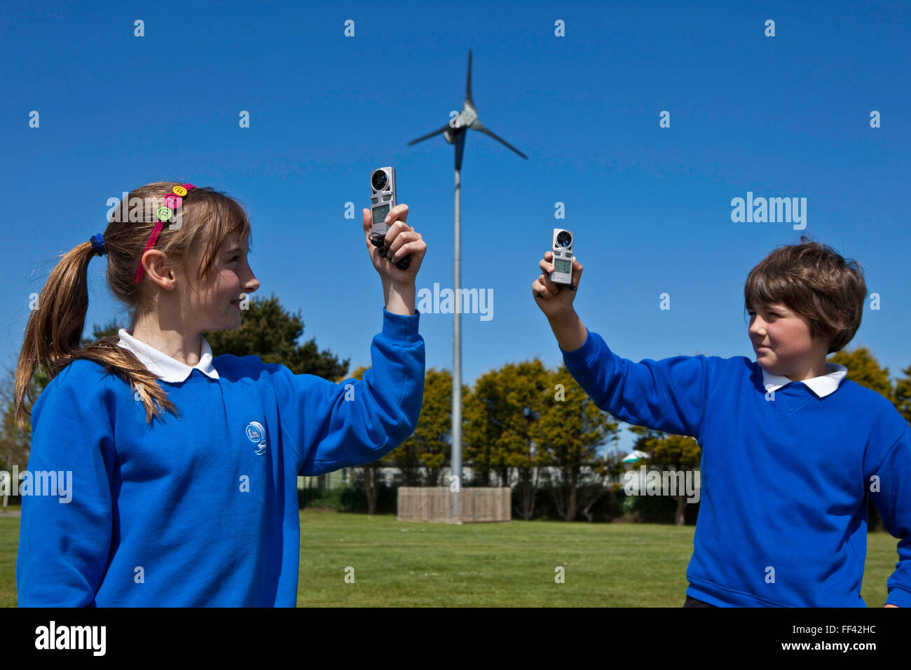 Primary school children measuring wind speeds with anemometers to help ...