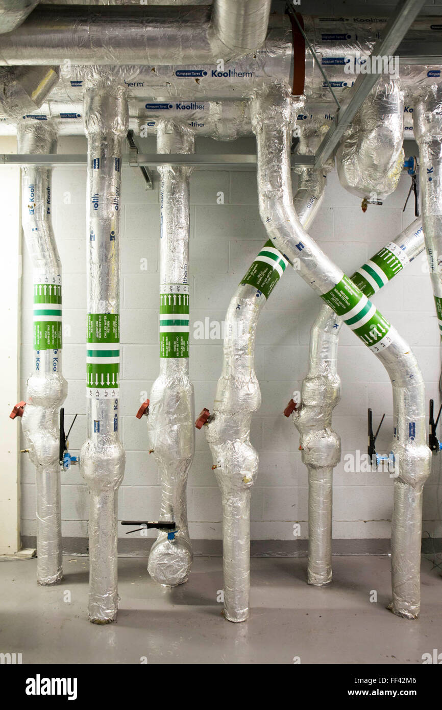 Foil insulated heating system pipes, inside the boiler room of a modern ...