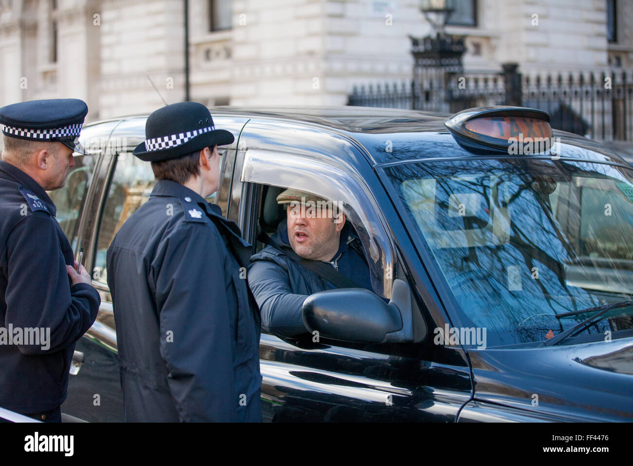 London, UK. 10th February 2016. A black cab taxi driver talks to police ...