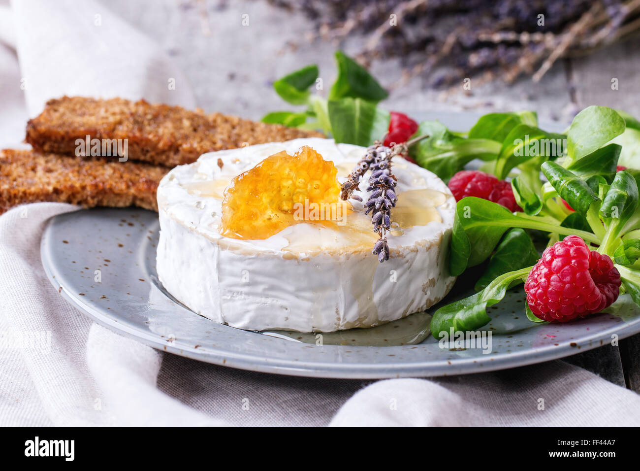 Goat cheese with honey and raspberries Stock Photo - Alamy