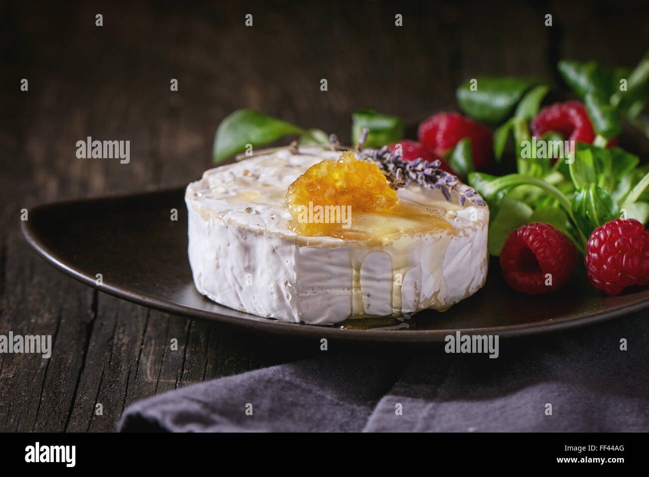 Goat cheese with honey and raspberries Stock Photo - Alamy