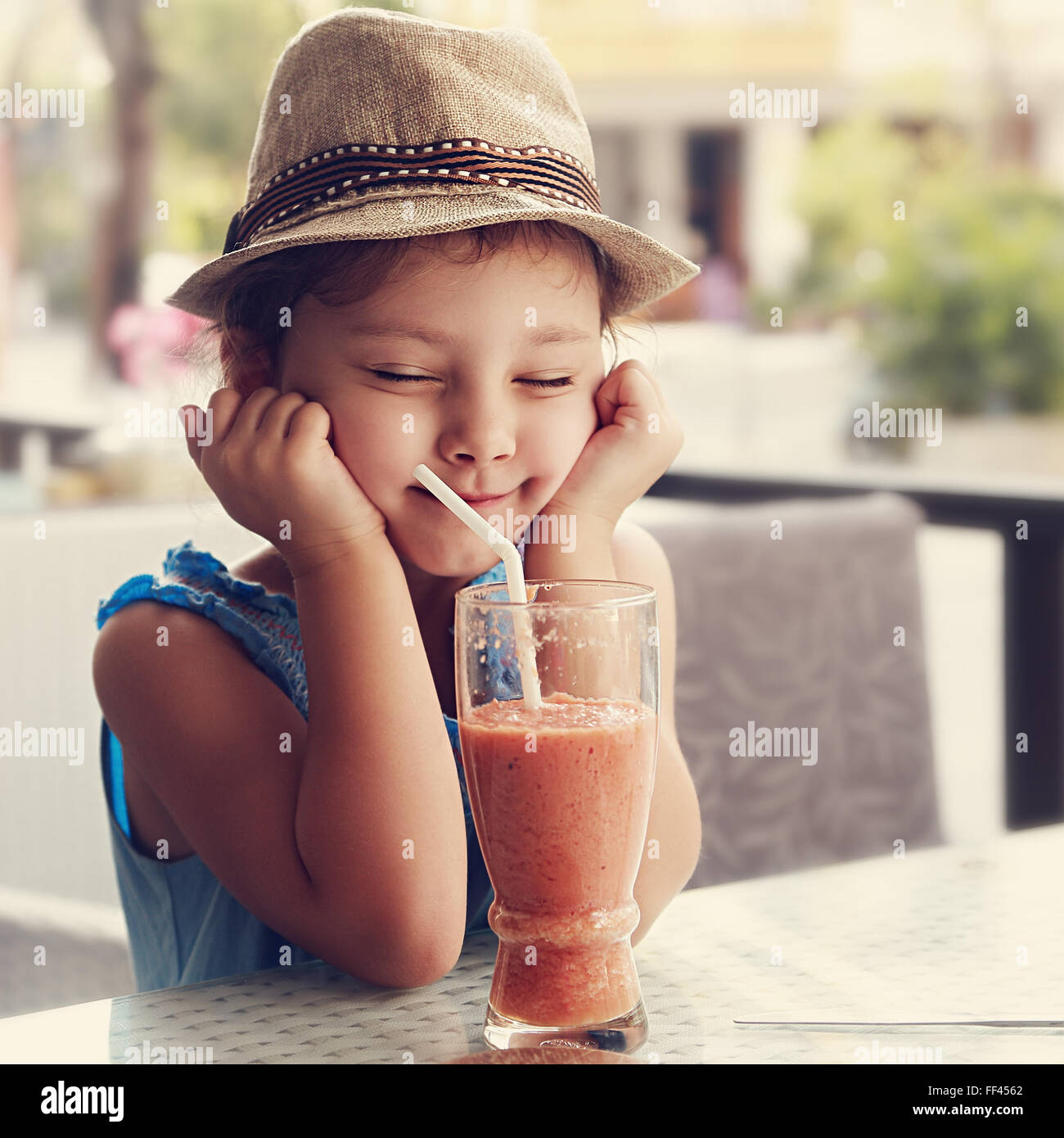 Fun kid girl in hat screwing up her eyes and waiting the moment to ...