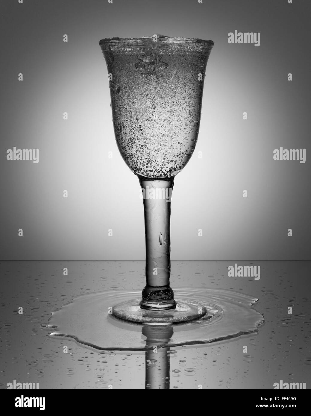 Glass with a drink pouring in and splashing out Stock Photo - Alamy