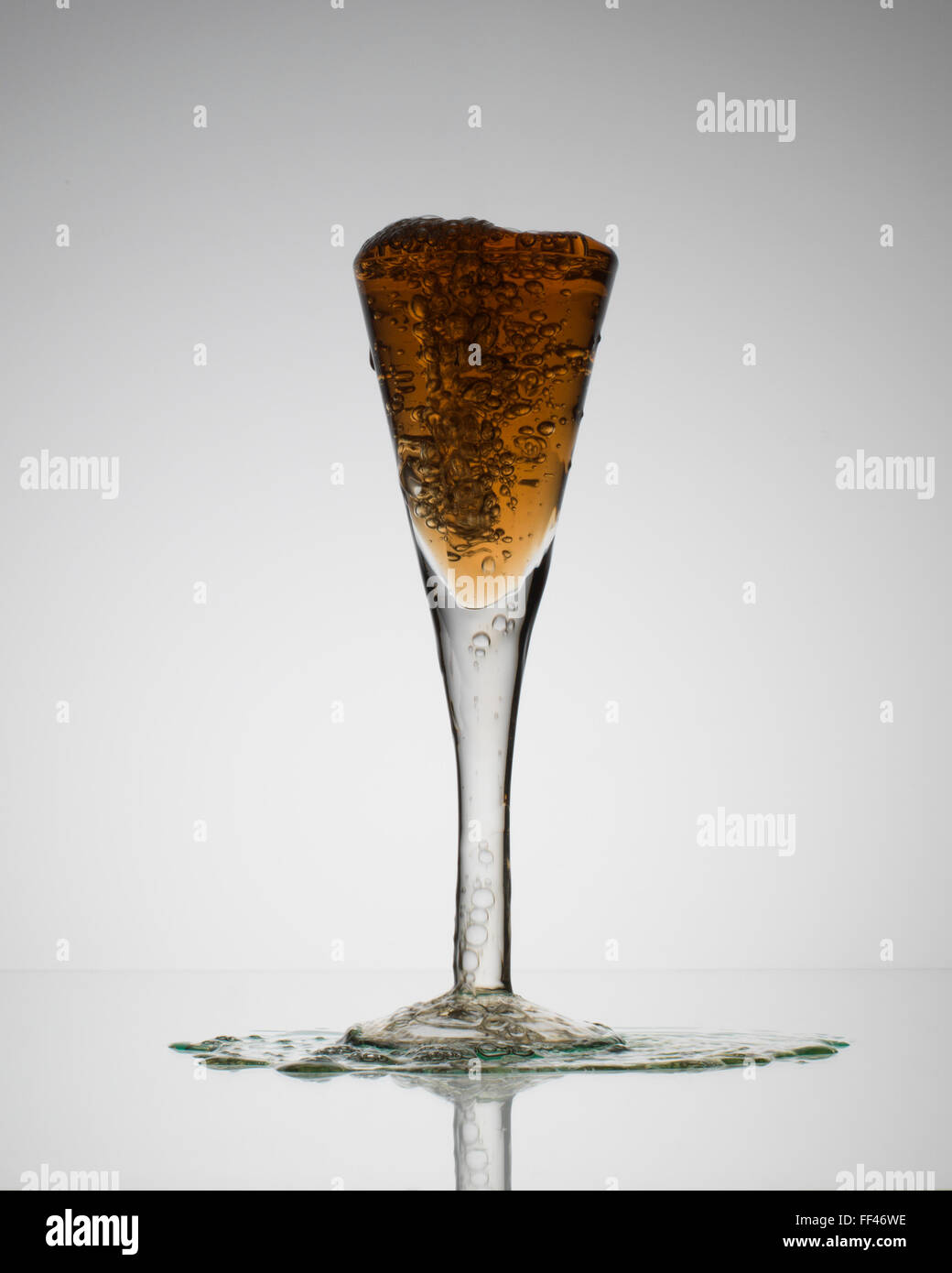 Glass with a drink pouring in and splashing out Stock Photo - Alamy