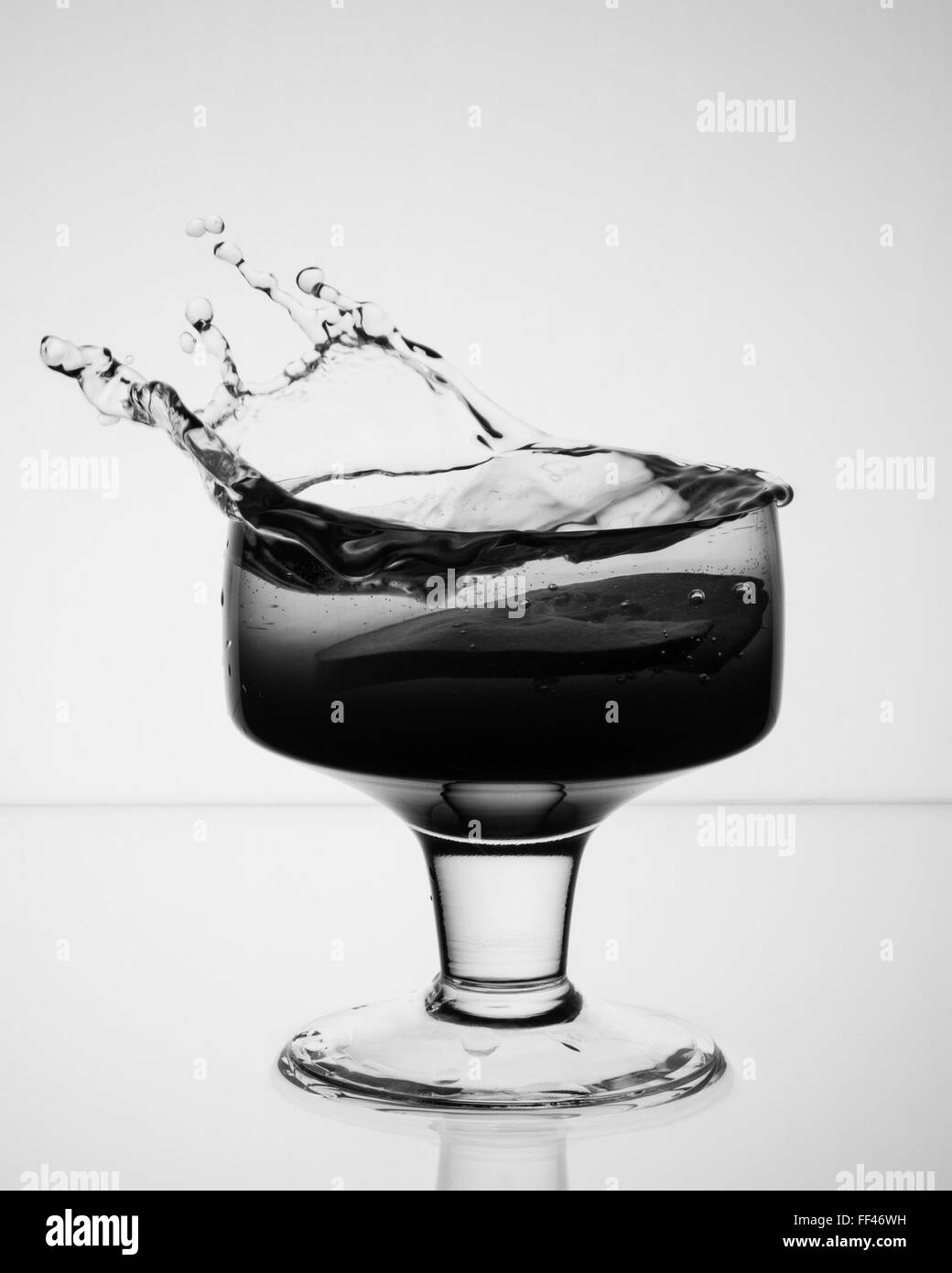 Glass with water splashing out Stock Photo - Alamy