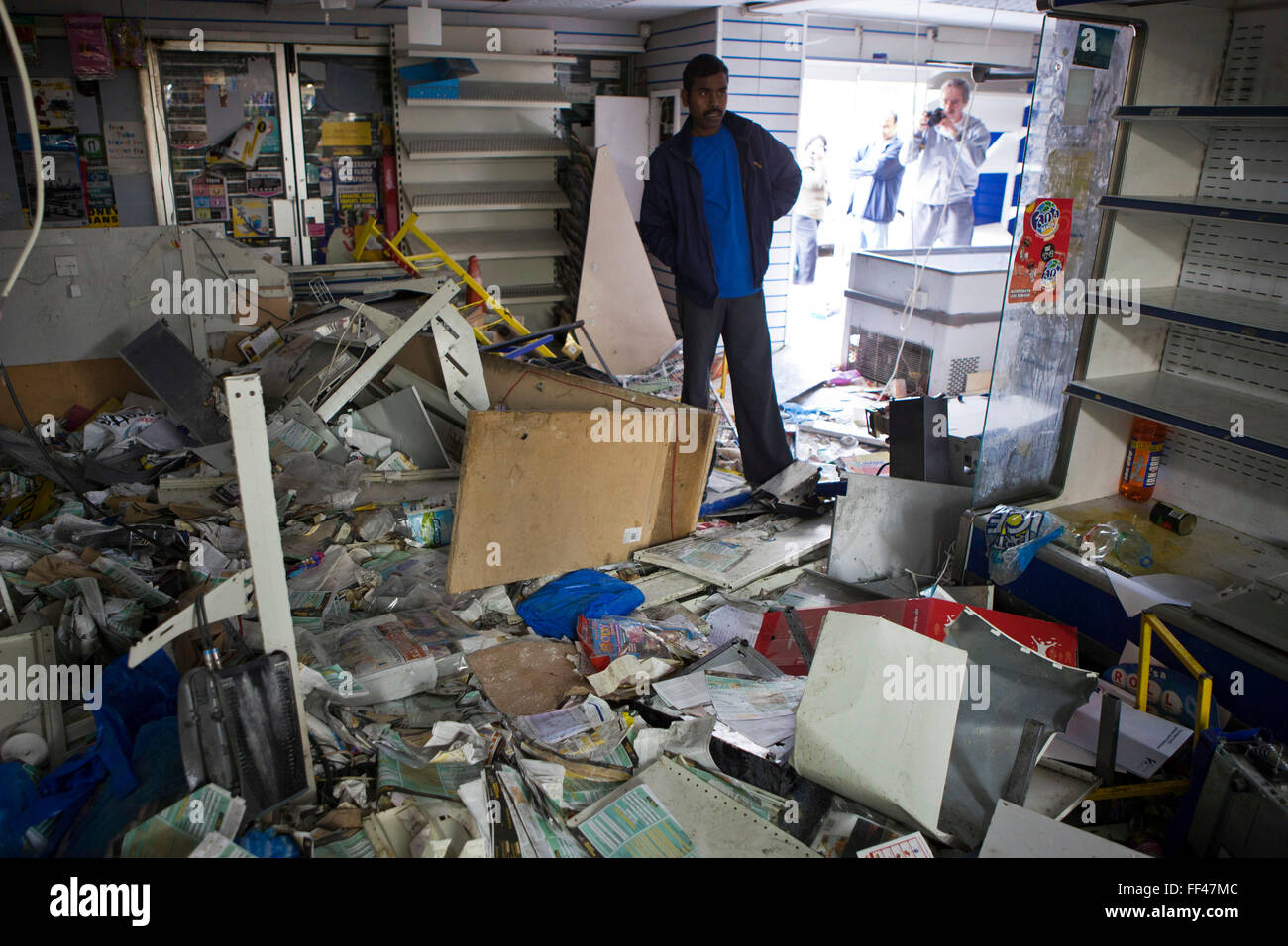 Ransacked and looted. A friend of the owner assess the damage inside ...
