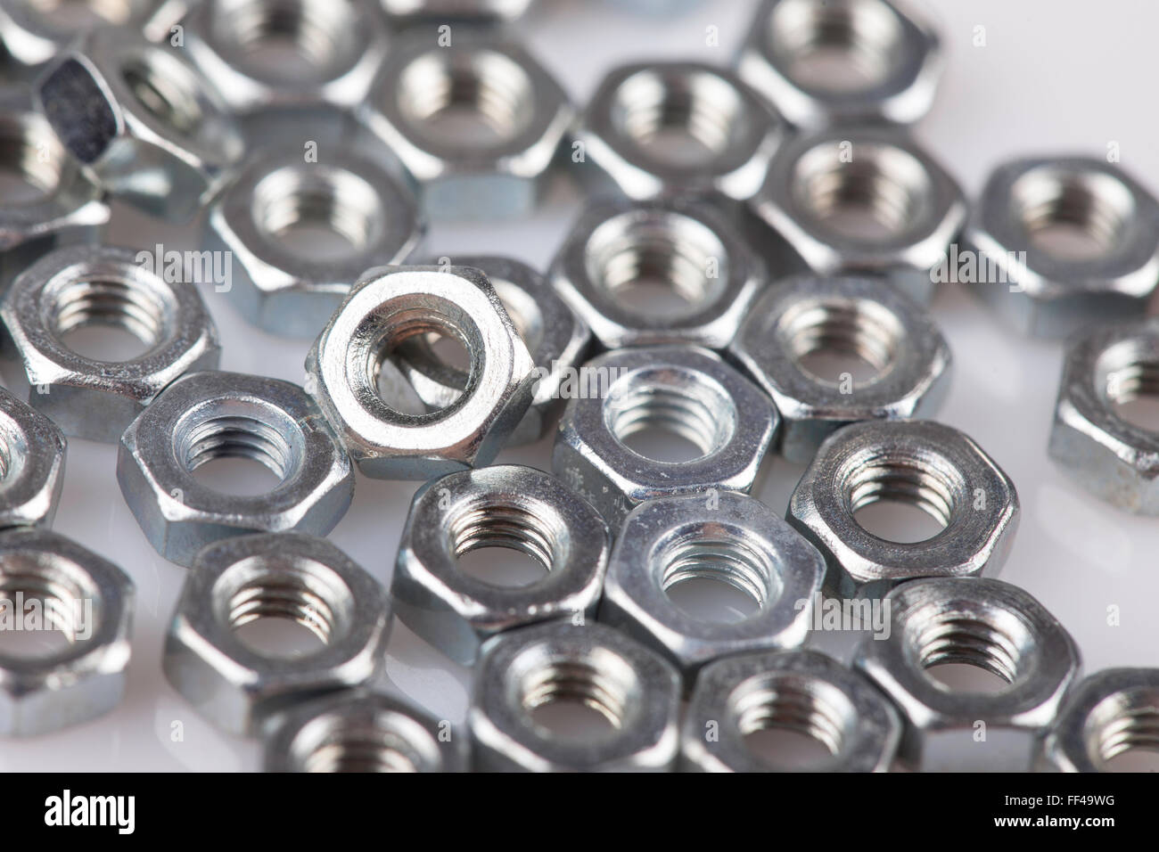 abstract background metal nuts closeup on white Stock Photo - Alamy